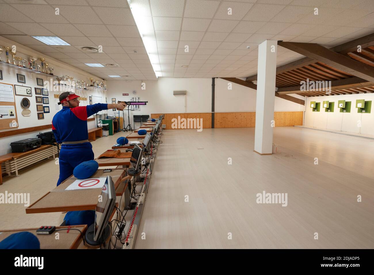 Shooter with professional air gun, during training at the firing range ...