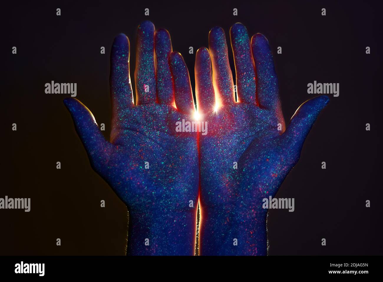 Beauty hands in ultraviolet light in drops of colored paint. Light ...