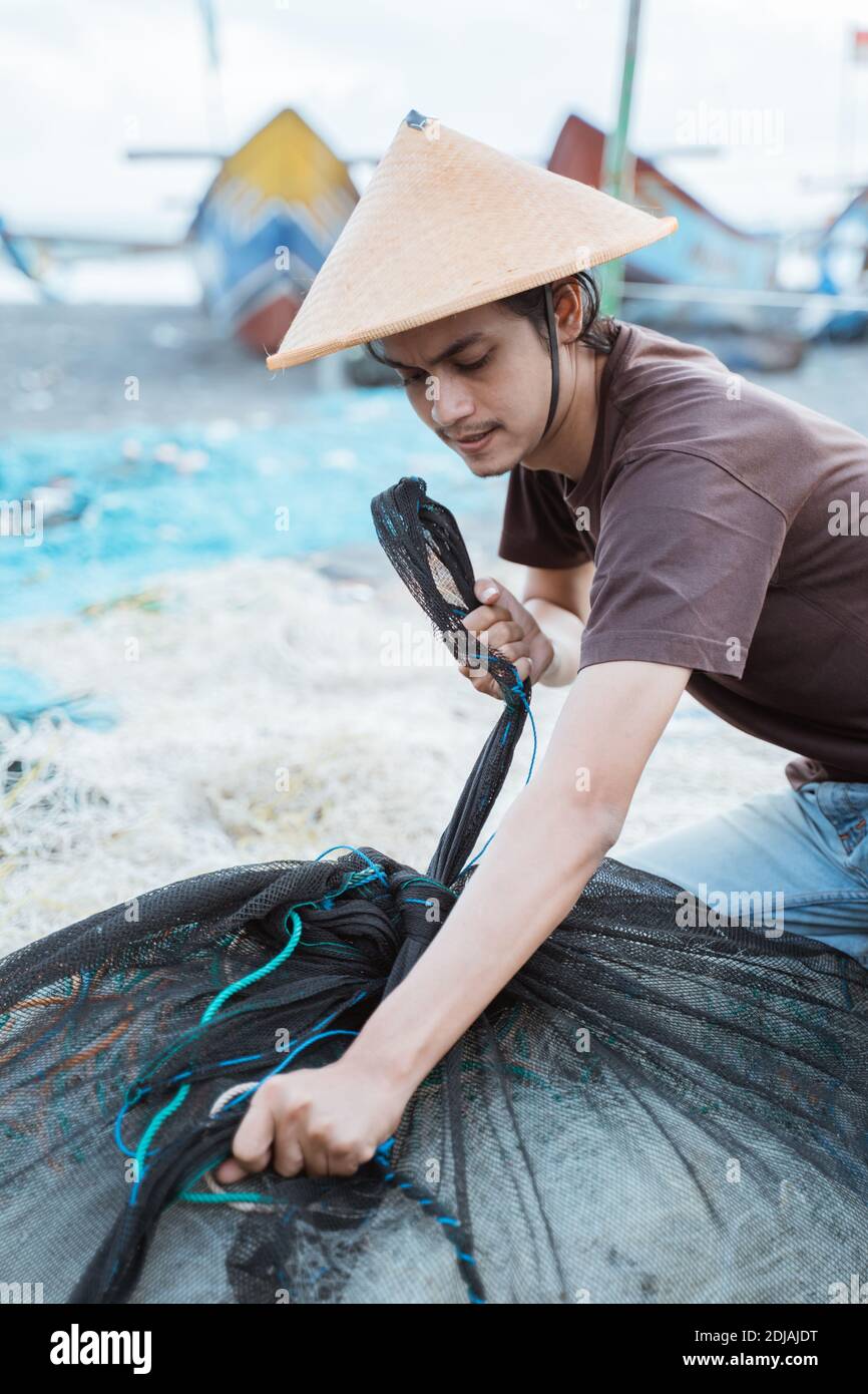 Portrait of a young male fisherman preparing a fishing net Stock Photo ...