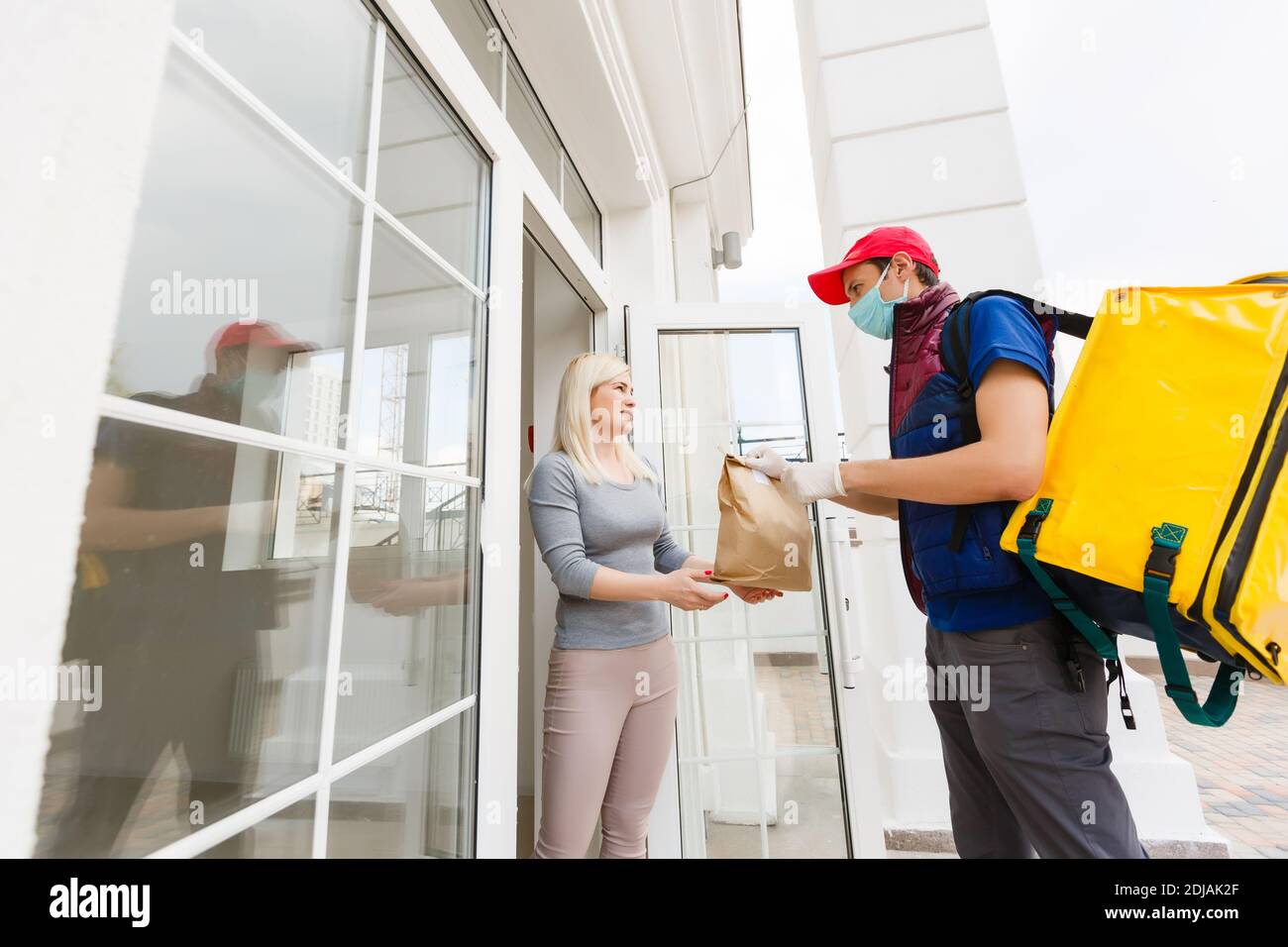 Delivery Man standing with yellow thermo backpack for food delivery ...