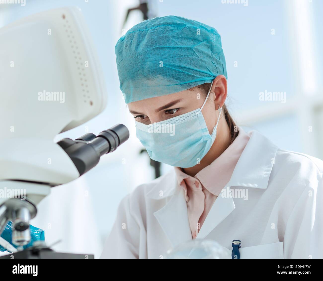 close up. female researcher looking through a microscope Stock Photo ...