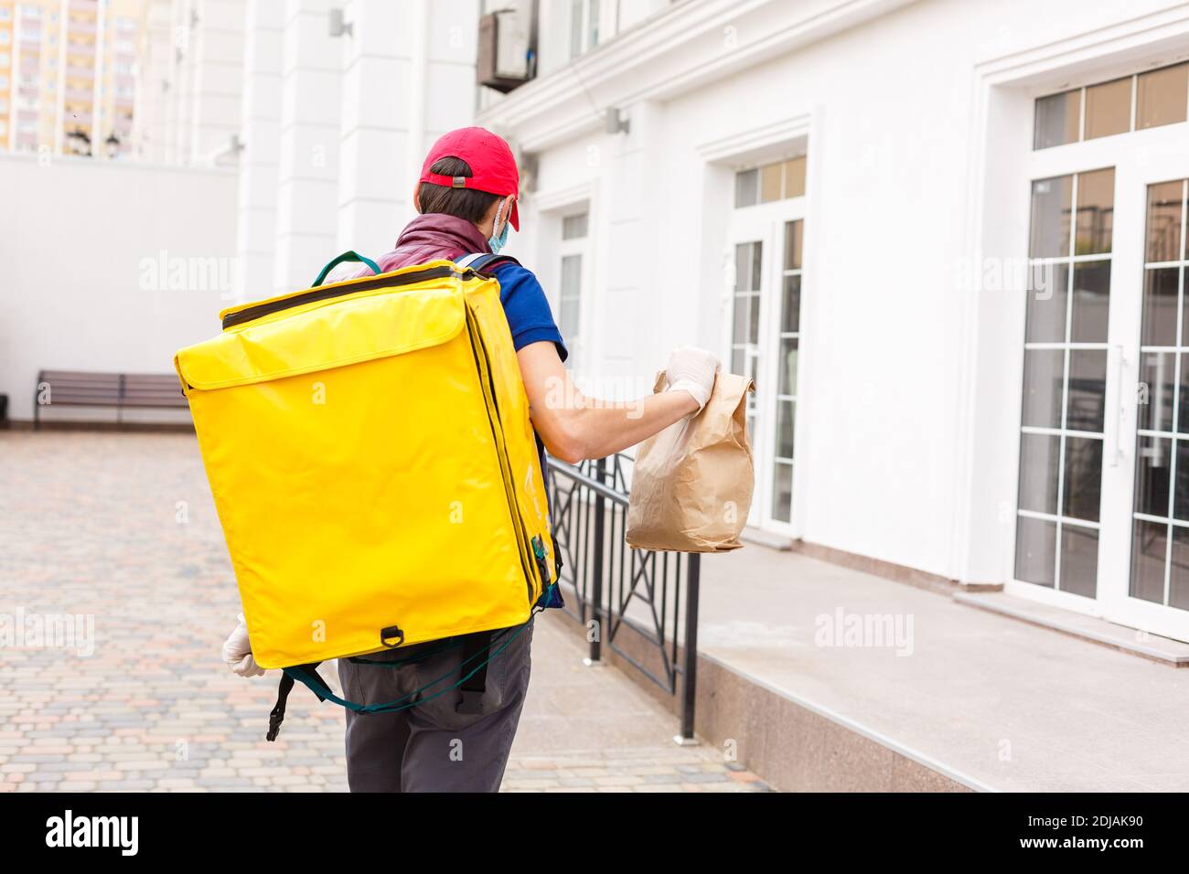 Delivery Man standing with yellow thermo backpack for food delivery ...