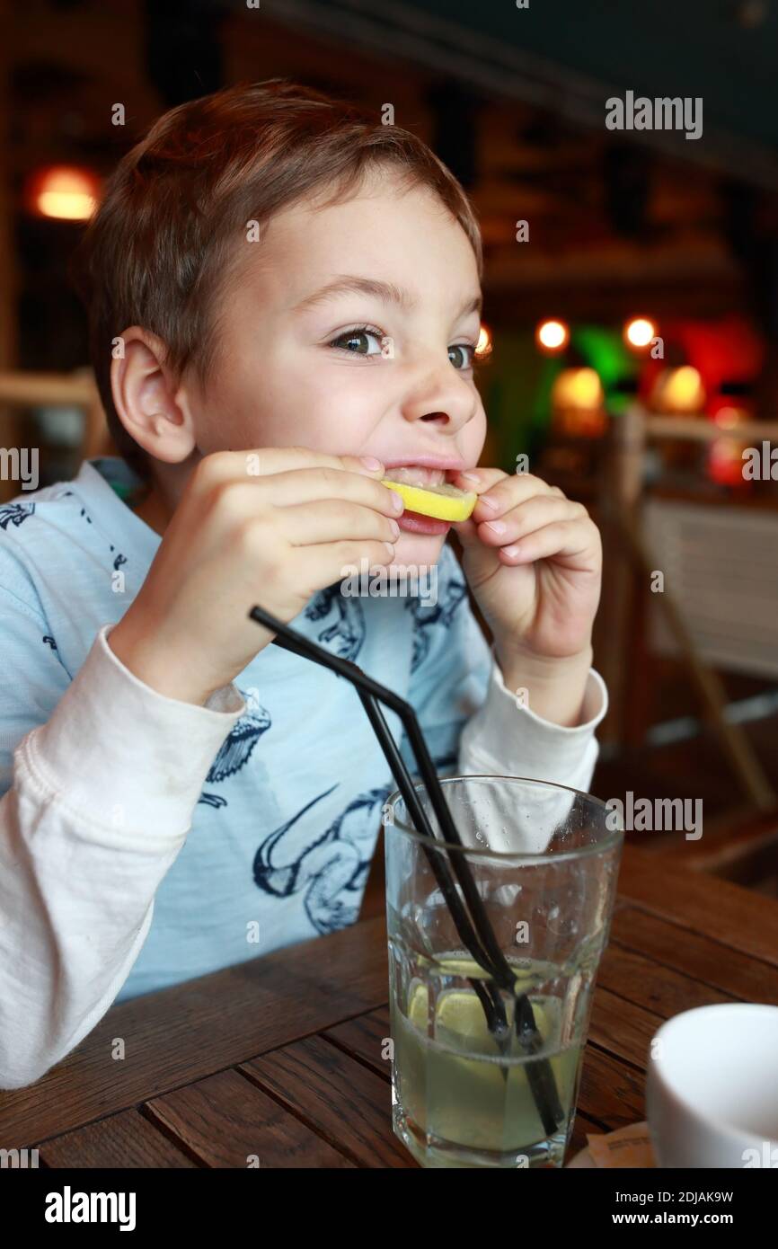 Child drinking lemonade at table in cafe Stock Photo - Alamy