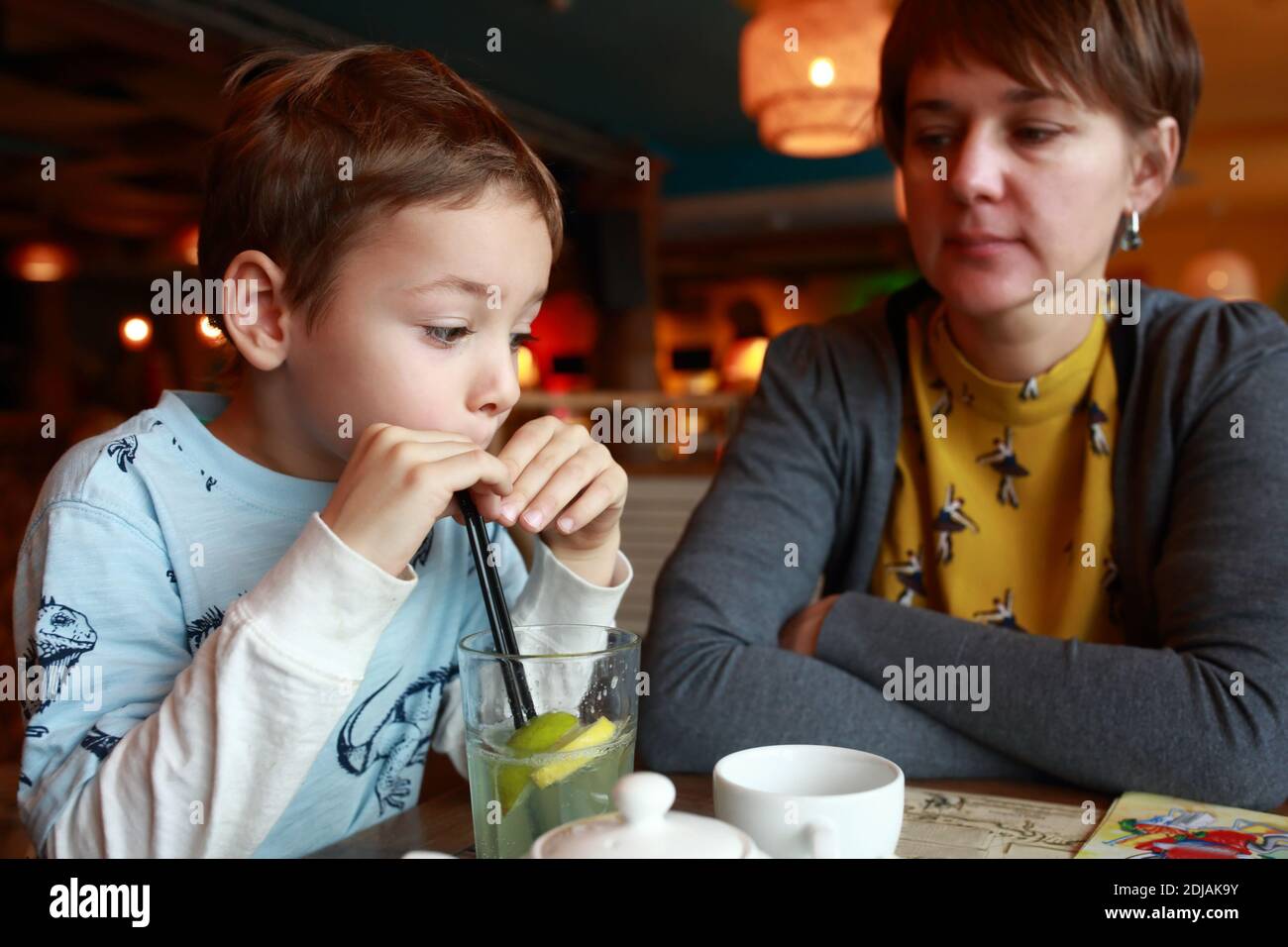 Boy has lemonade at table in a restaurant Stock Photo - Alamy