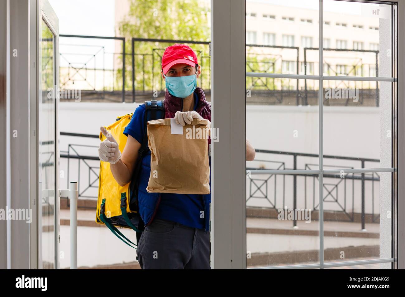 Delivery Man standing with yellow thermo backpack for food delivery ...