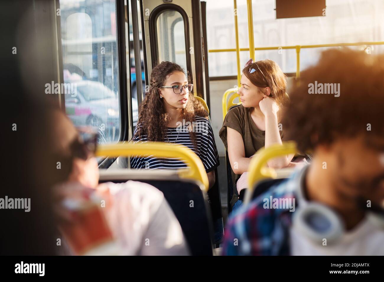 Two young beautiful female friends are sitting at the rear end of the ...