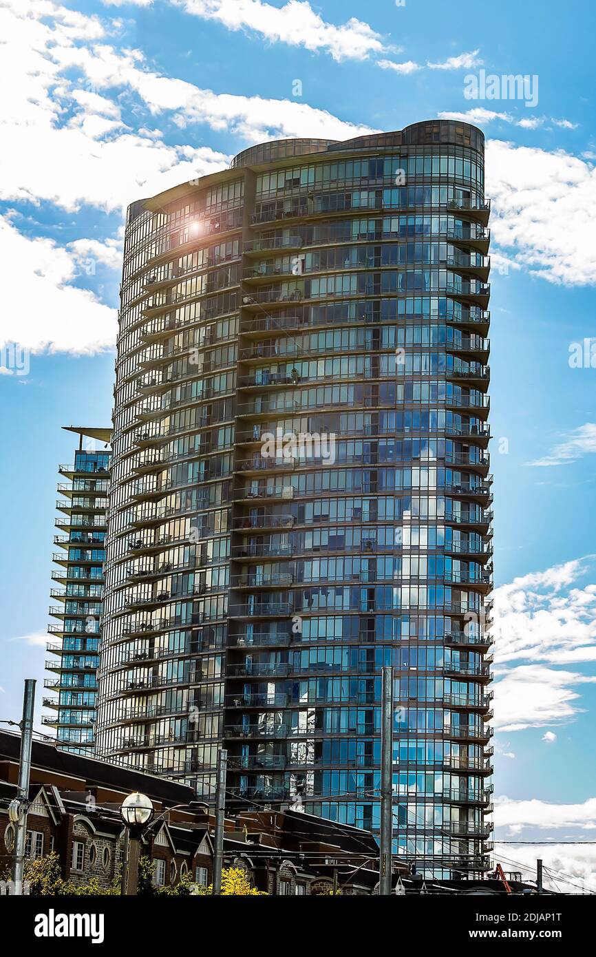 An apartment building, glass windows covering it from top to bottom in ...