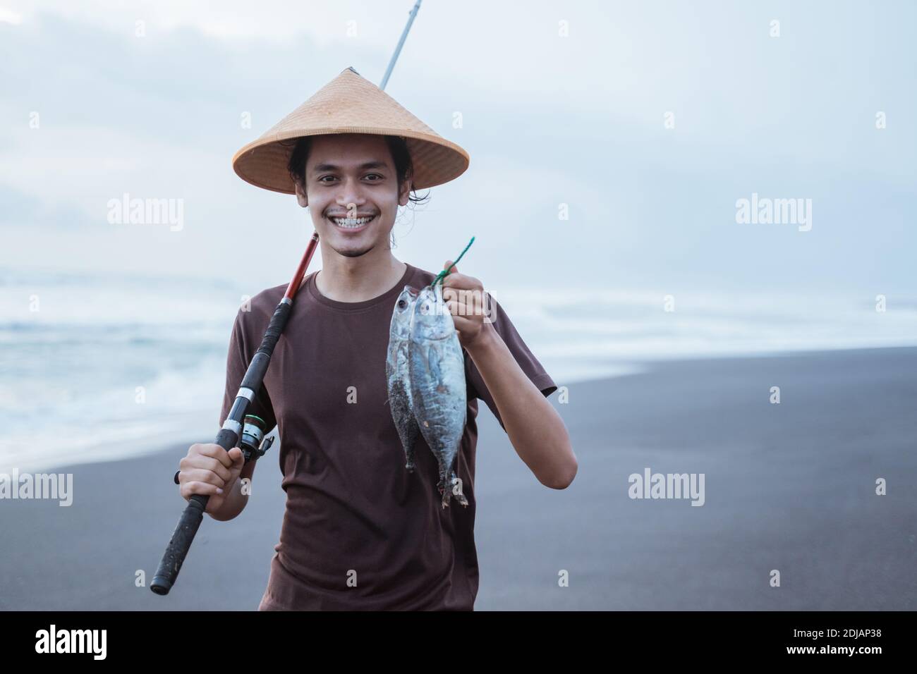 Close up young fisherman showing his captured fish on the beach Stock ...