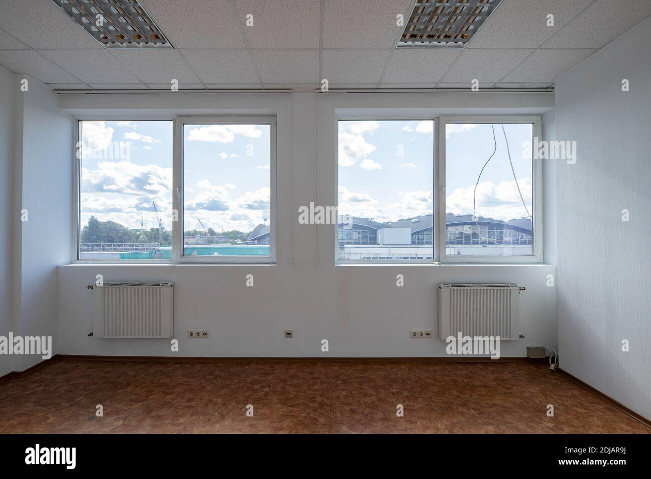 Modern interior of empty office room. Couple of windows and heating ...