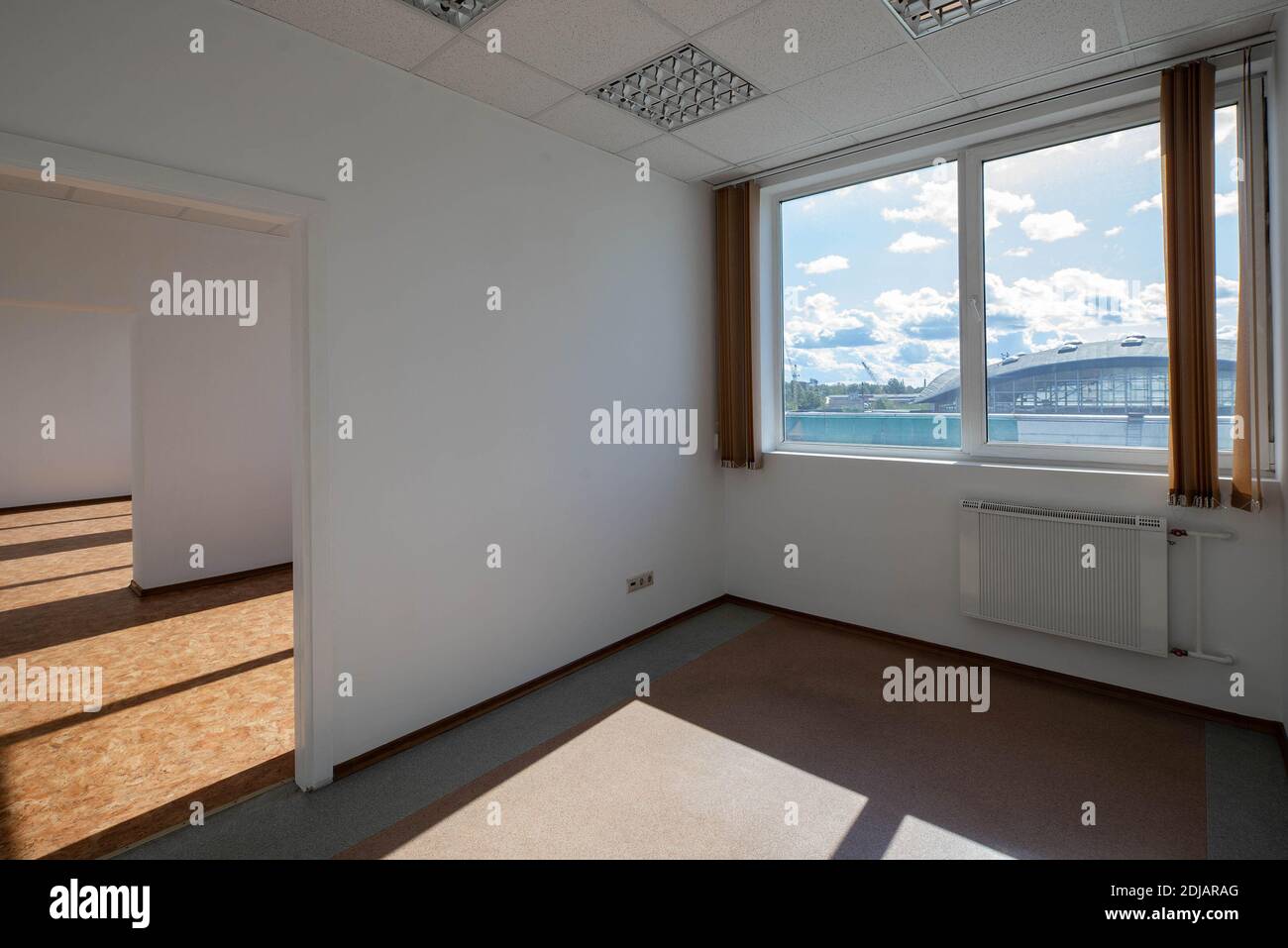 Modern interior of empty office room. White walls and door. Huge window ...