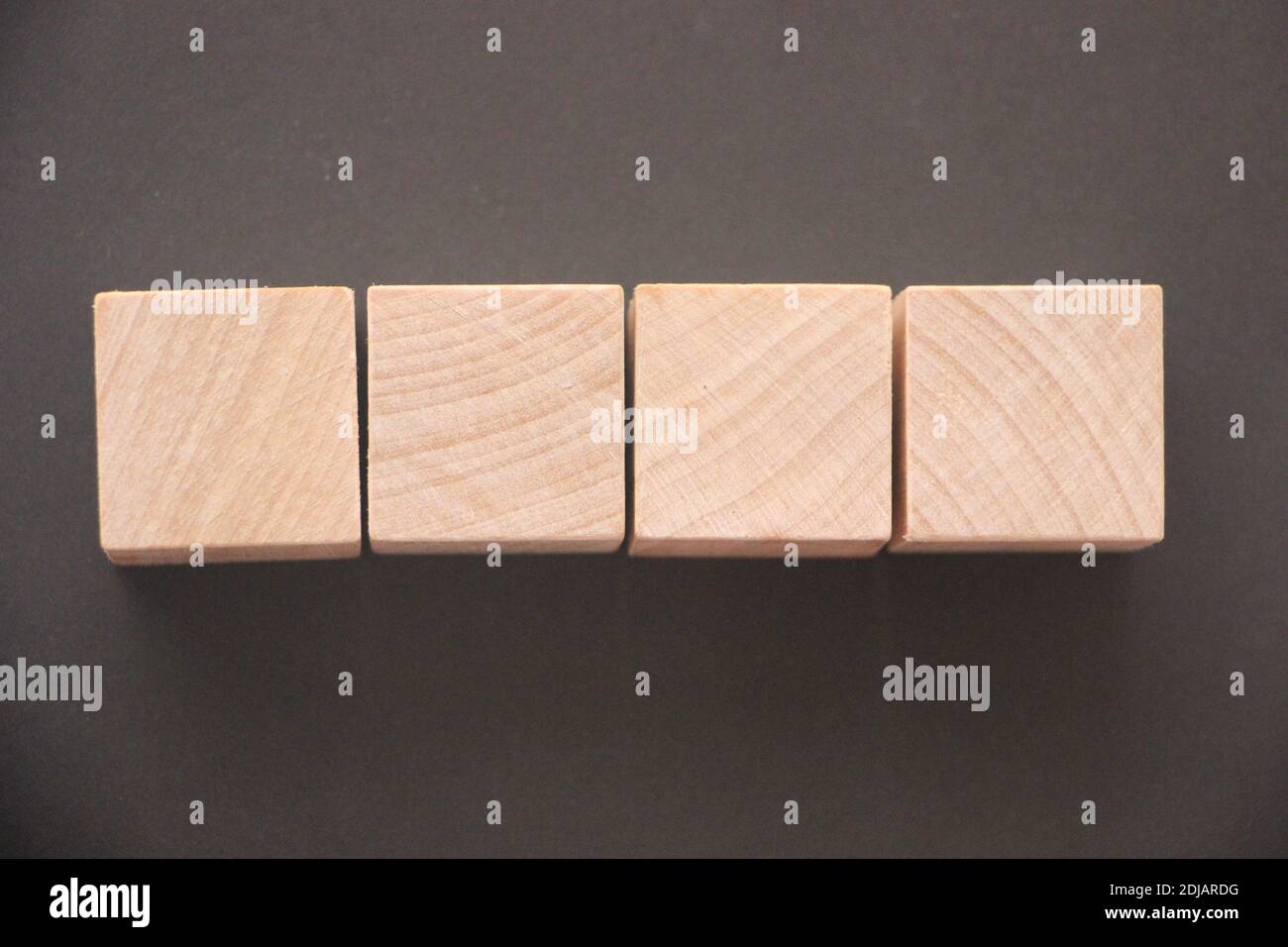 Four wooden blocks on table on black background. Education concept ...