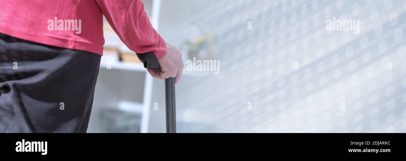 Senior woman walking with a cane at home; panoramic banner Stock Photo ...
