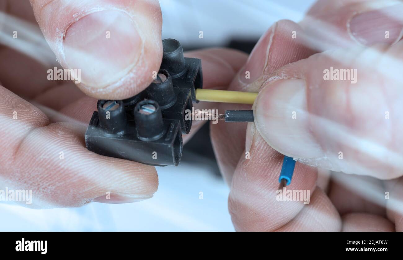 Hand putting a wire in a connector; light effect Stock Photo - Alamy