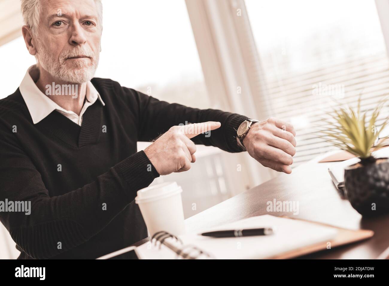 Businessman pointing his finger on his wrist watch Stock Photo - Alamy