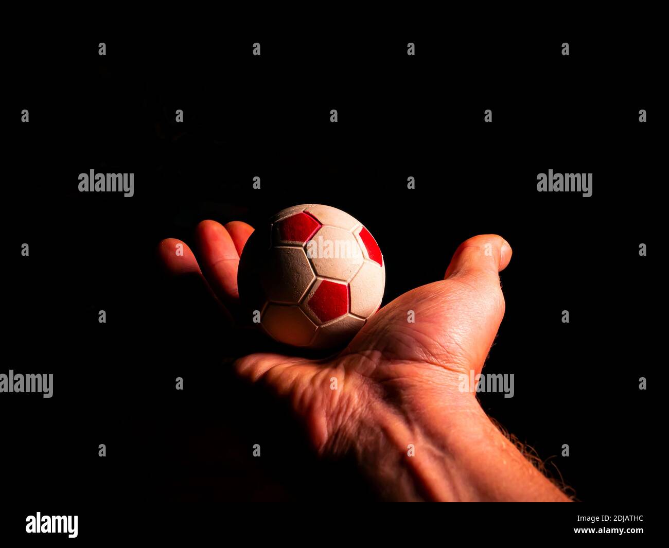 Soccer ball in hand on a black background. Soccer ball. Palms of human ...