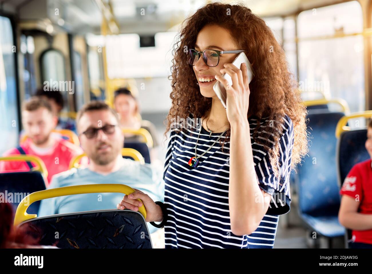 Young beautiful happy woman is talking on the phone smiling while ...