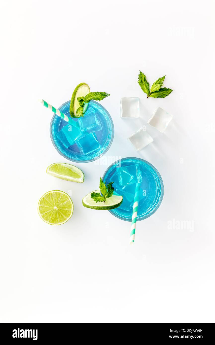 Blue beverage, iced alcohol cocktail drink with lime and mint, top view ...