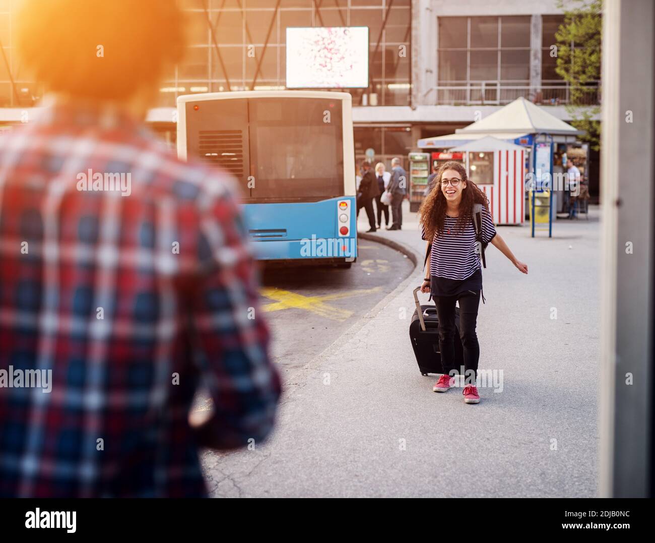 After a long travel a young beautiful cheerful woman is happy to see ...