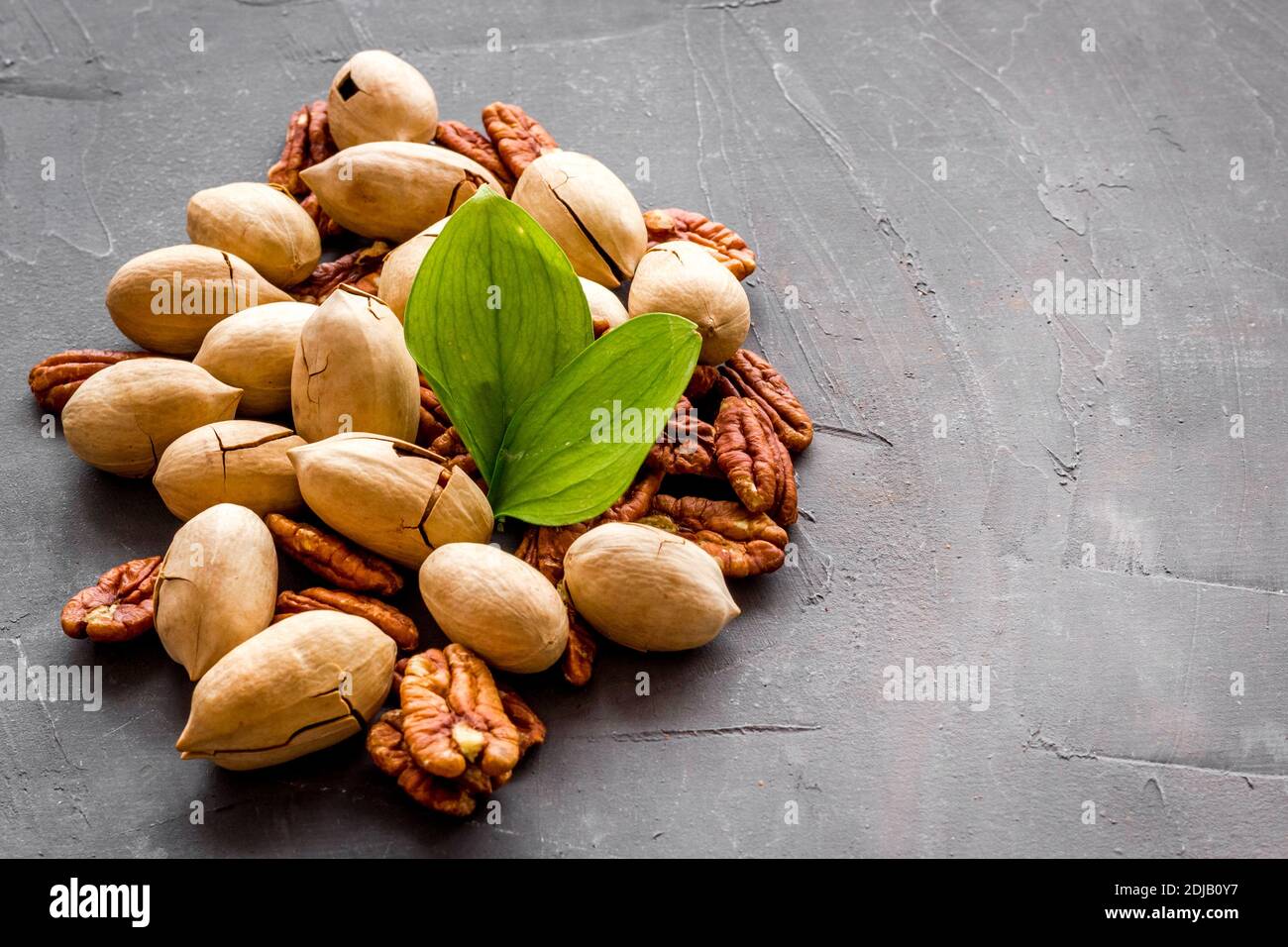 Pile of pecan nuts with green leaves on kitchen table, close up Stock ...