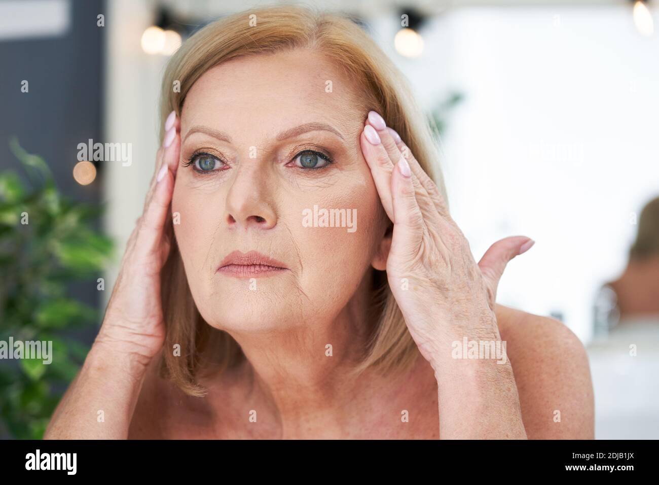 Senior woman using anti wrinkle cream in the bathroom Stock Photo - Alamy