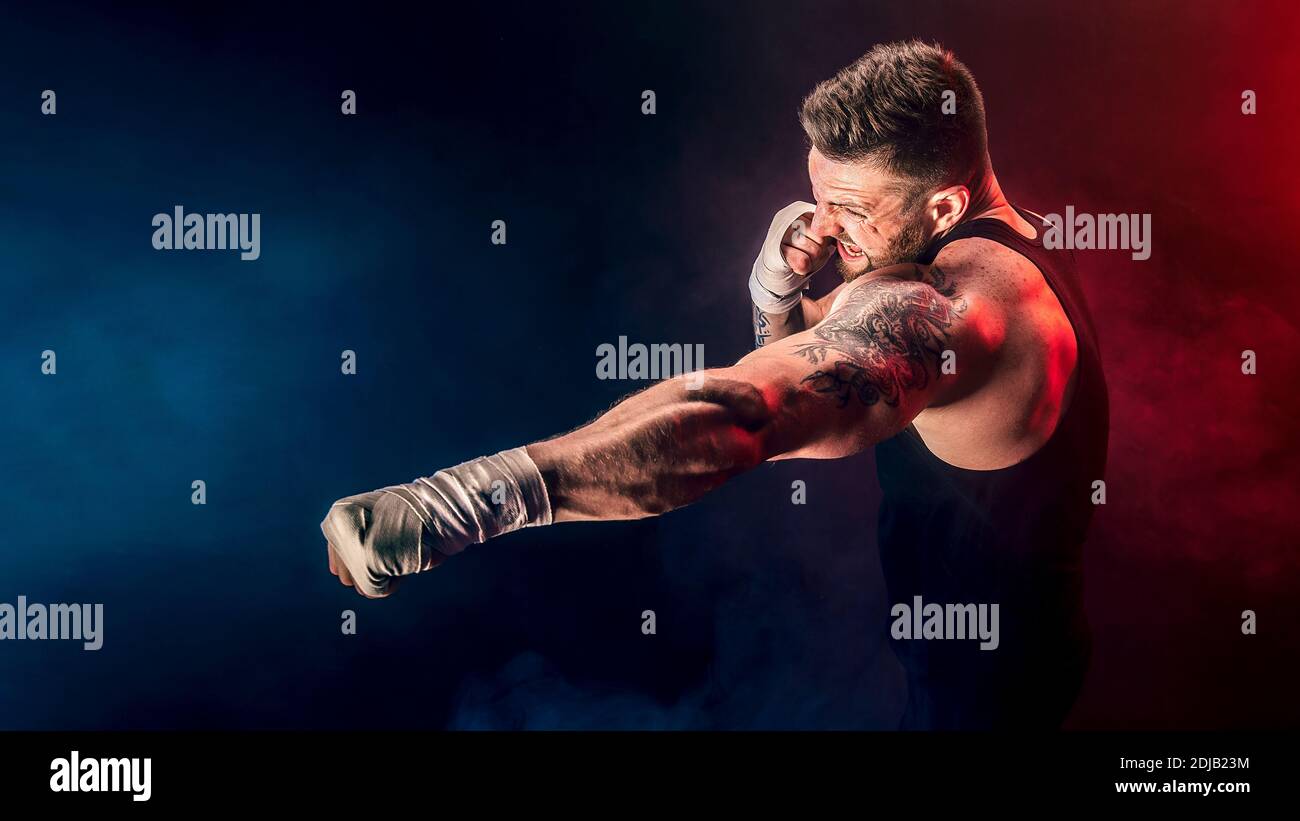 Sportsman muay thai boxer fighting on black background with smoke ...