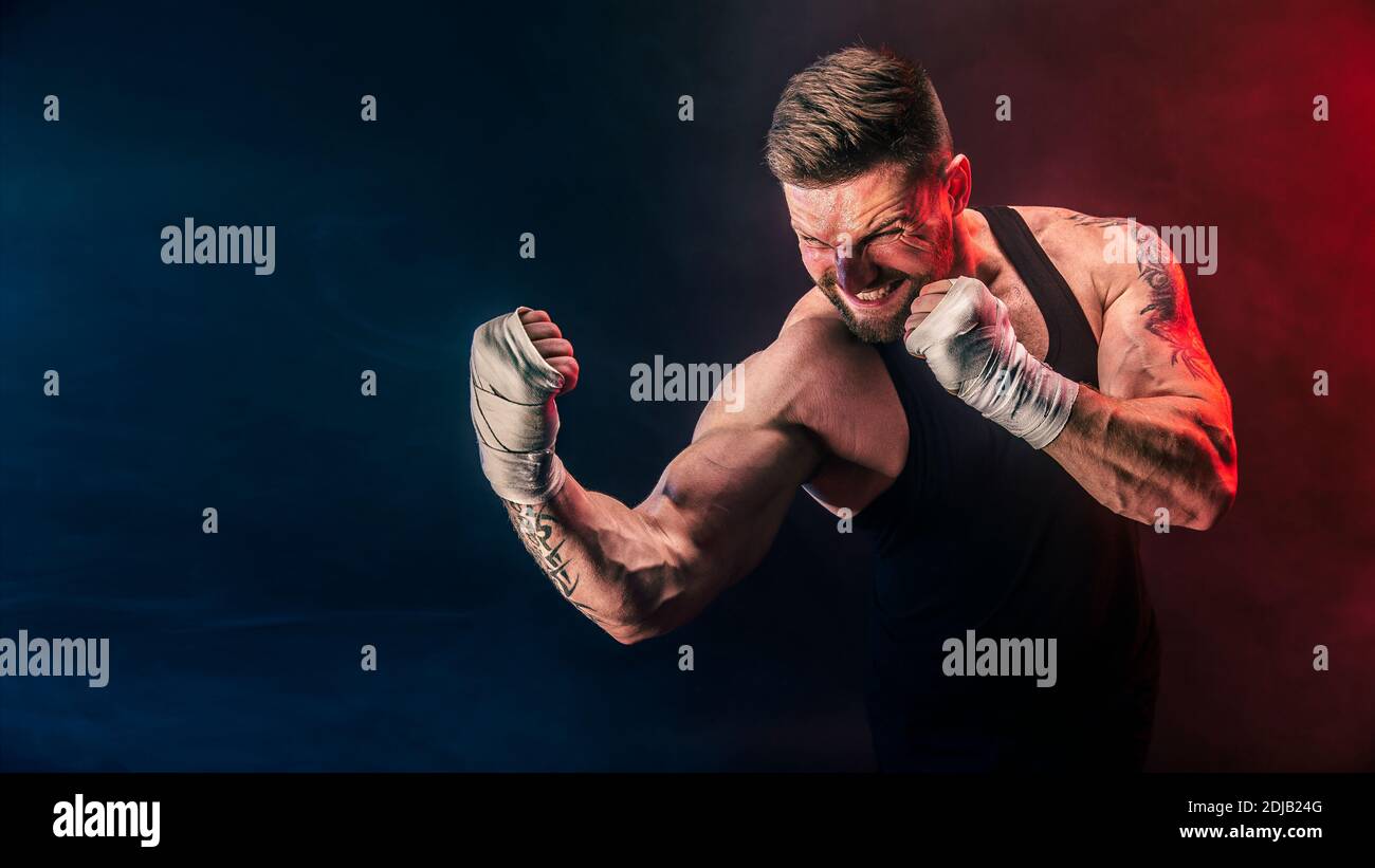 Sportsman muay thai boxer fighting on black background with smoke ...