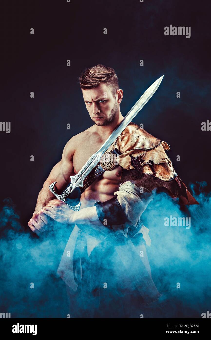 Portrait of angry gladiator with sword looking up against of black ...