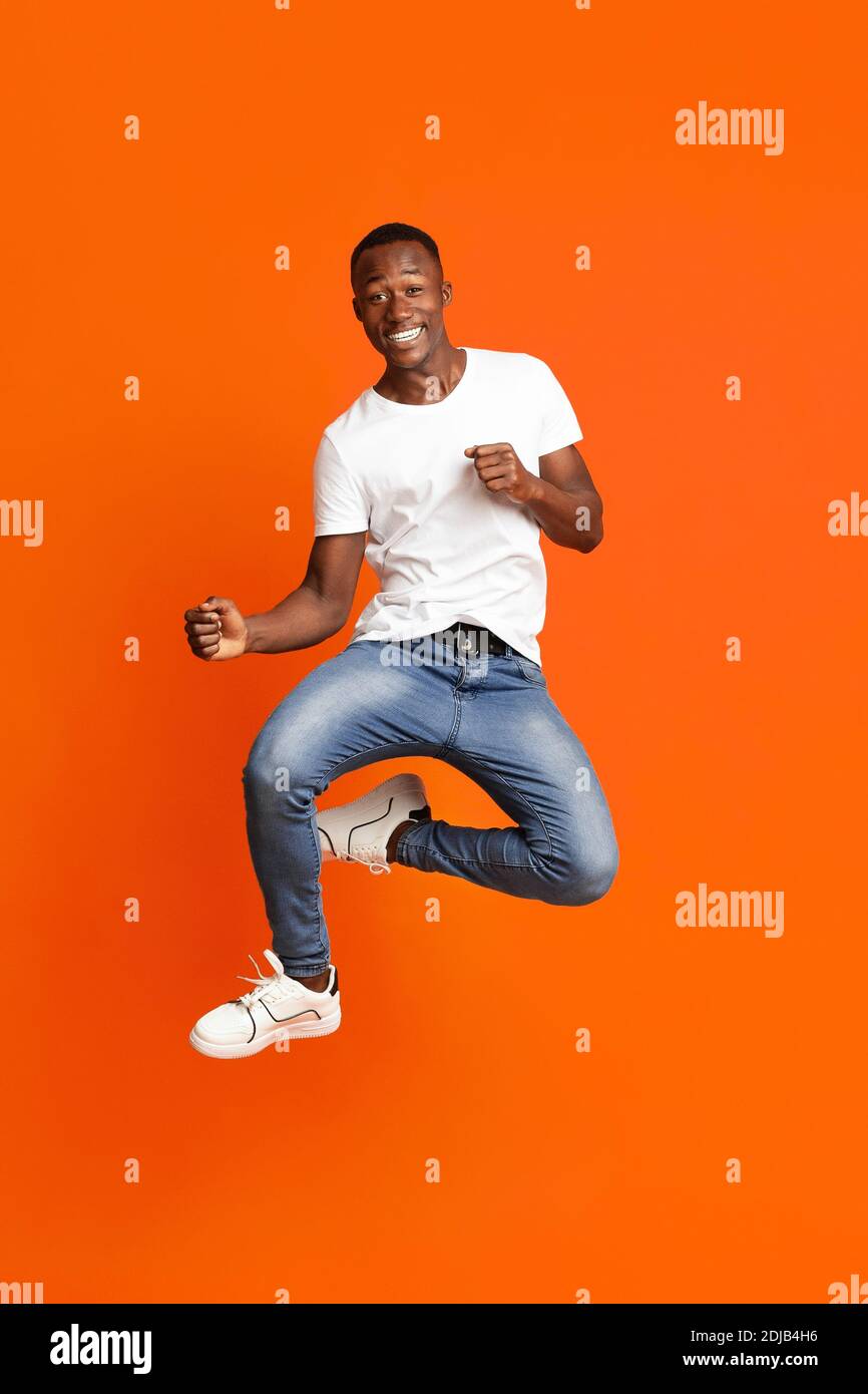 Black guy jumping in the air and showing funny figures Stock Photo - Alamy