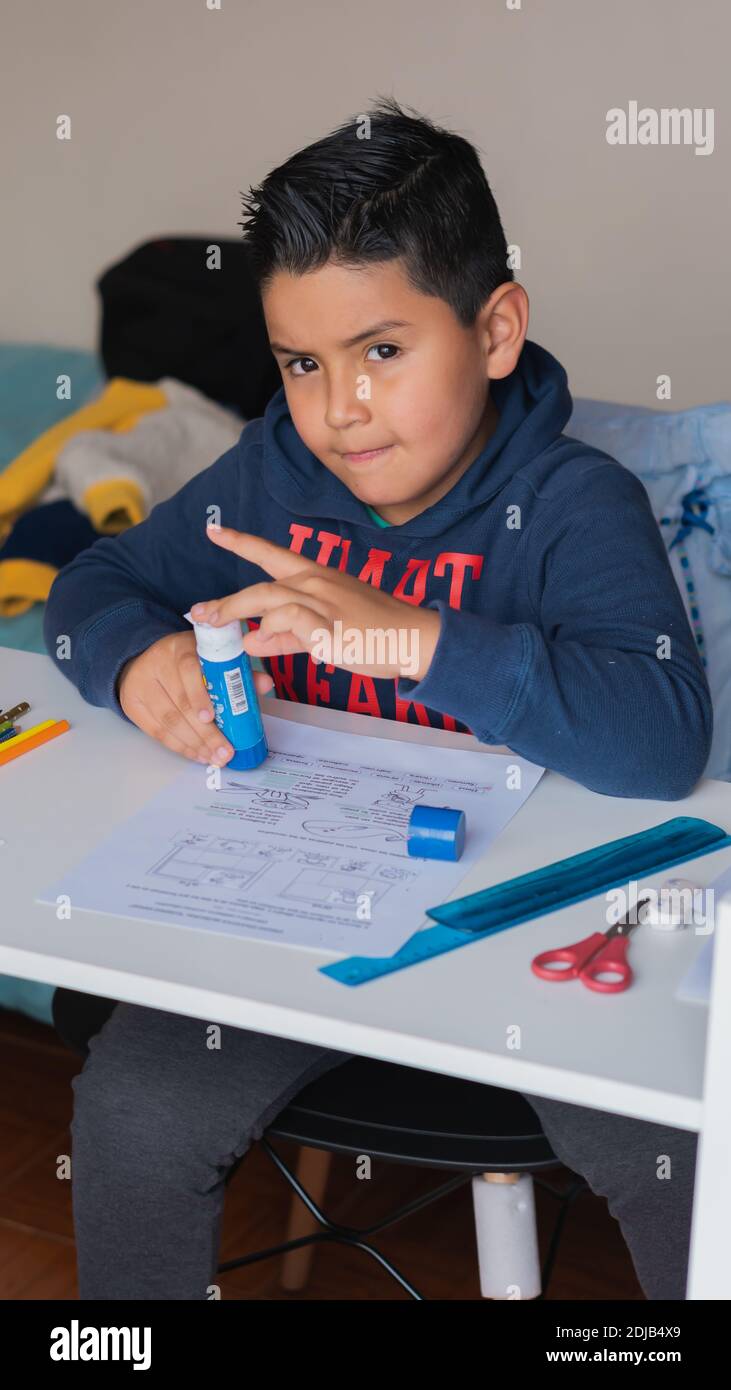 A vertical closeup of a Hispanic child studying at home Stock Photo - Alamy