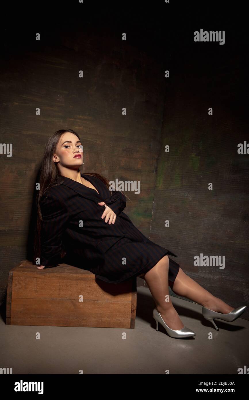 Caucasian female inclusive model posing on studio background in classic ...