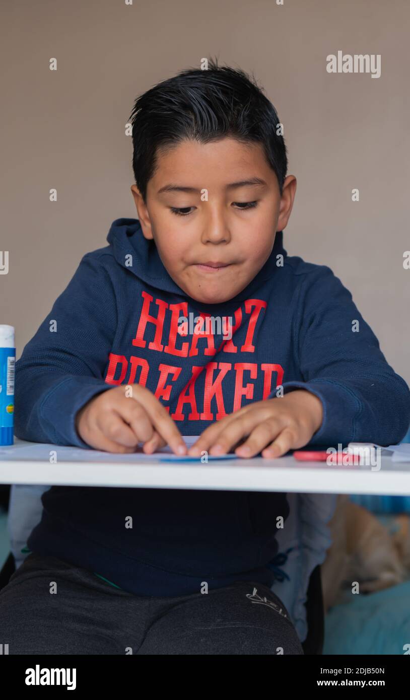 A vertical closeup of a Hispanic child studying at home Stock Photo - Alamy