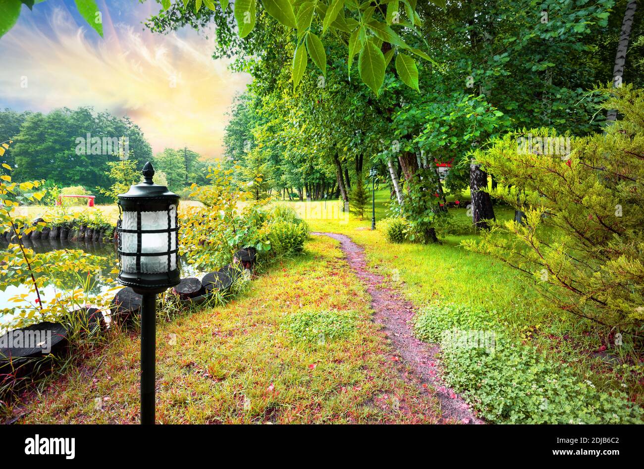 Path past lake in park with lantern Stock Photo - Alamy