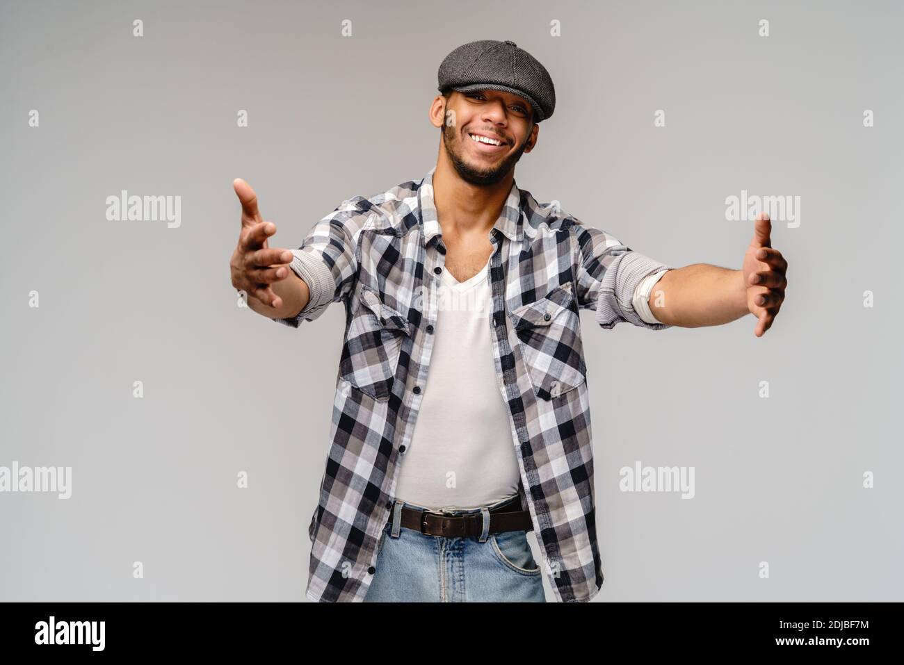 african american young handsome man over grey background looking at the ...