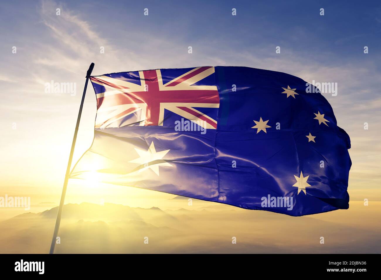 Australia flag waving on the top sunrise mist fog Stock Photo - Alamy