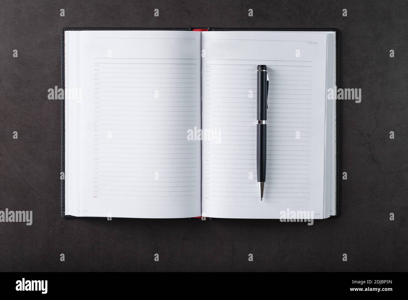 Office desk with black notepad and pen on black background. Top view ...