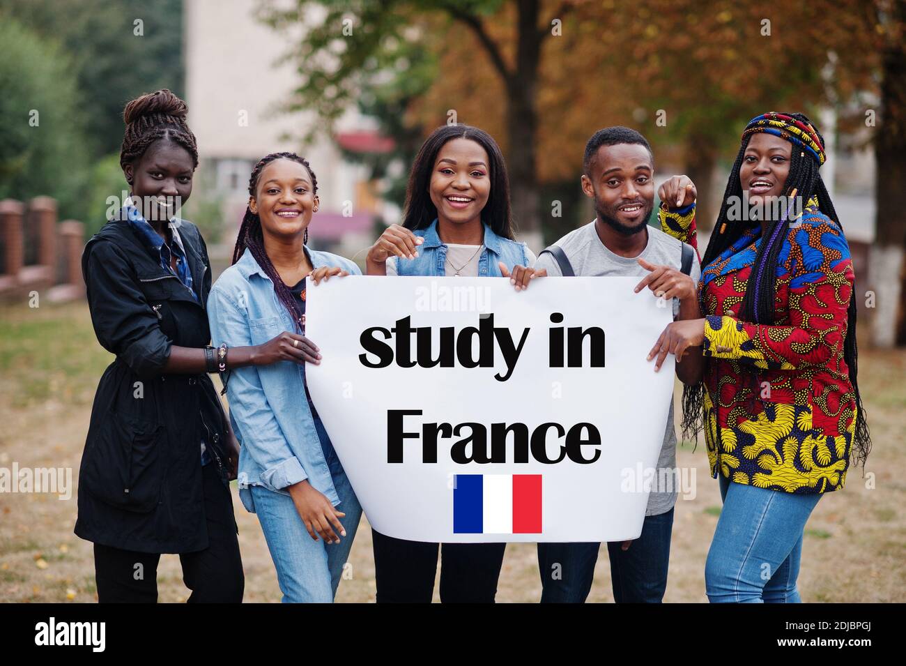 Study in France. Group of five african college students on campus at university yard hold white ...