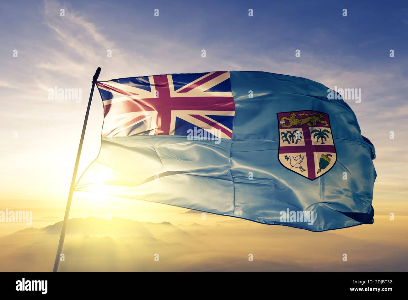Fiji flag waving on the top sunrise mist fog Stock Photo - Alamy