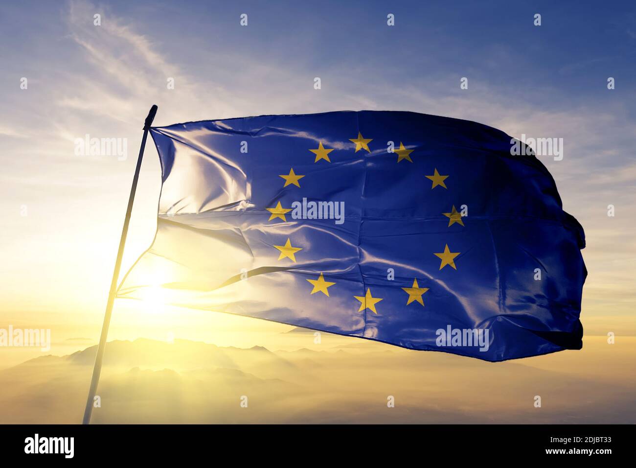 European Union flag waving on the top sunrise mist fog Stock Photo - Alamy