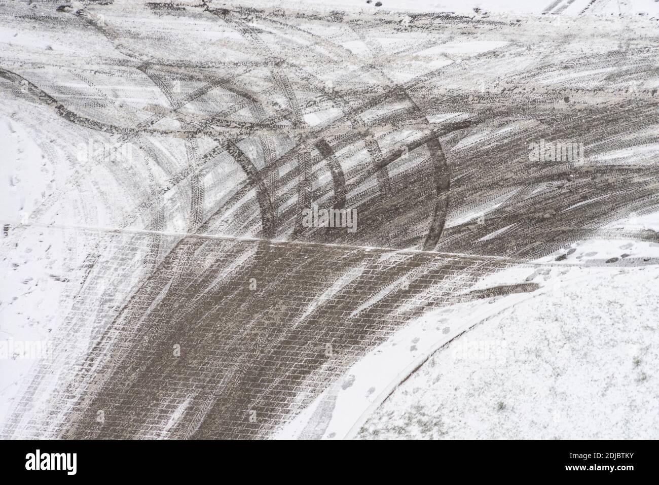 Tracks of car tires in thin layer of first snow in winter. Aerial view ...