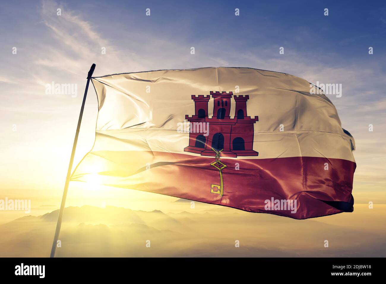Gibraltar flag waving on the top sunrise mist fog Stock Photo - Alamy