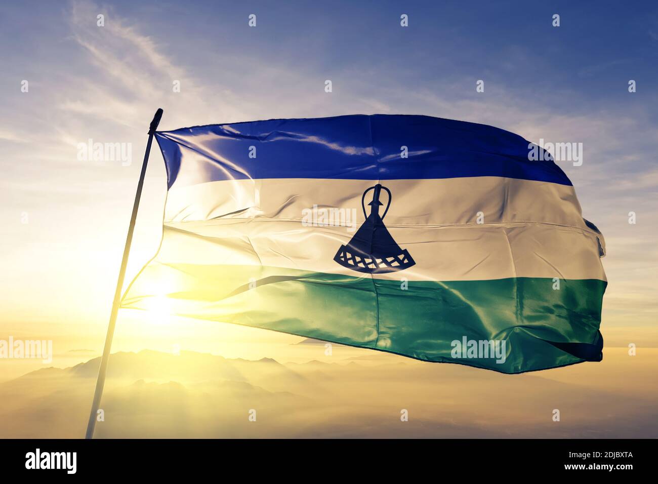 Lesotho flag waving on the top sunrise mist fog Stock Photo - Alamy