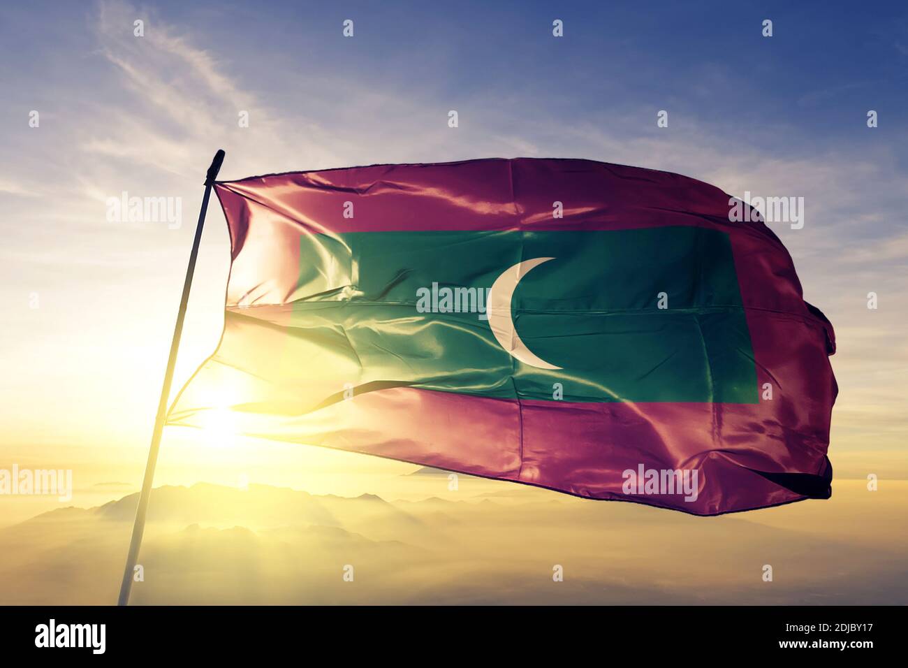 Maldives flag waving on the top sunrise mist fog Stock Photo - Alamy