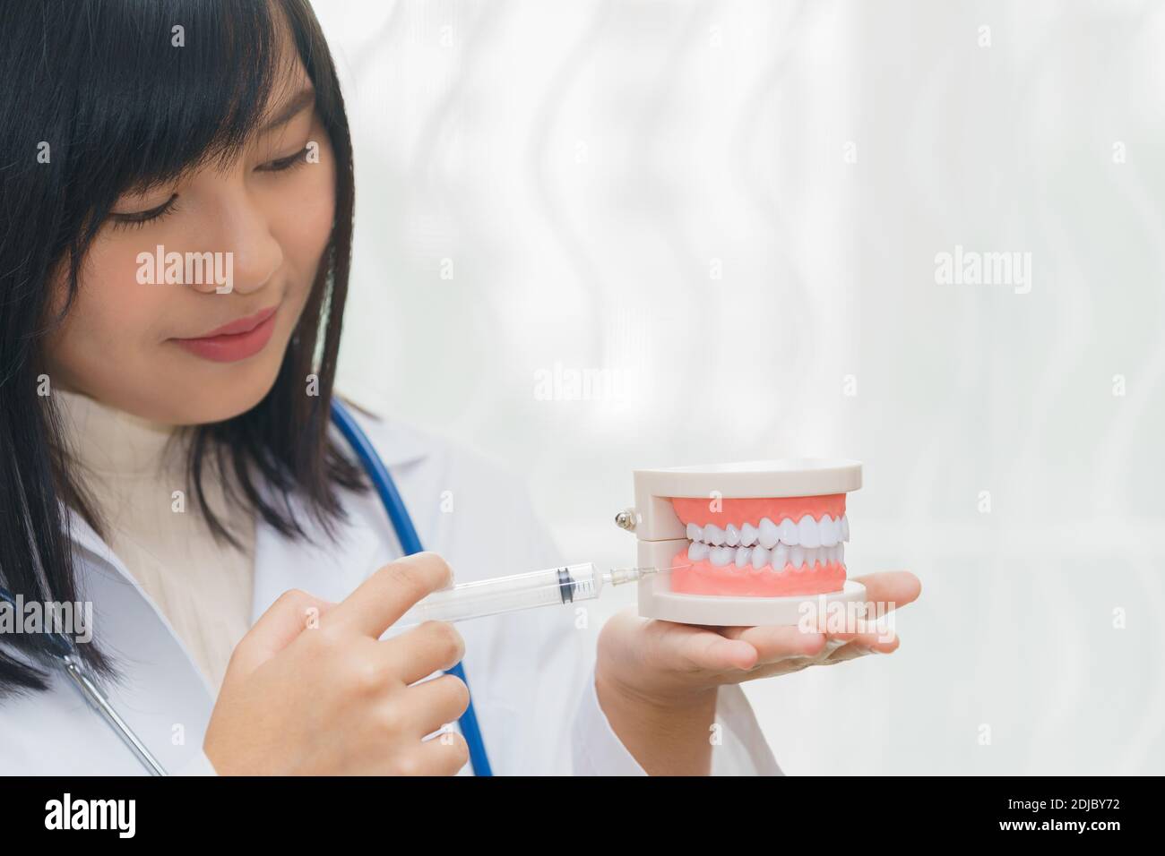 Dentist Injecting Syringe In Teeth Model Stock Photo - Alamy