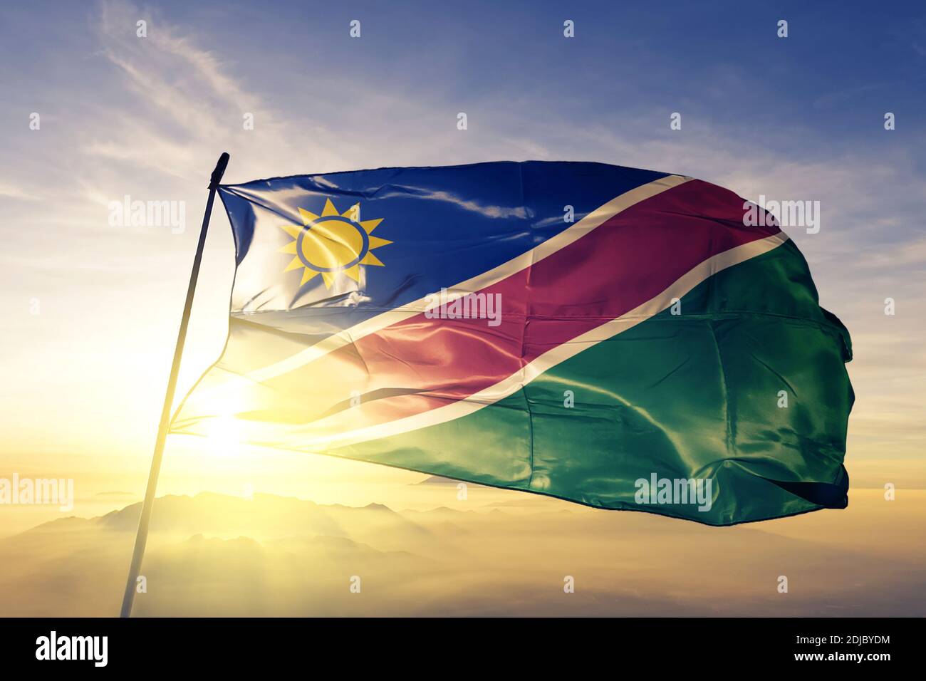 Namibia flag waving on the top sunrise mist fog Stock Photo - Alamy