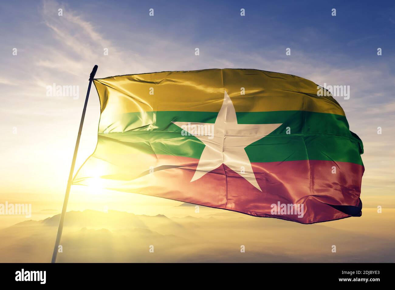 Myanmar flag waving on the top sunrise mist fog Stock Photo - Alamy