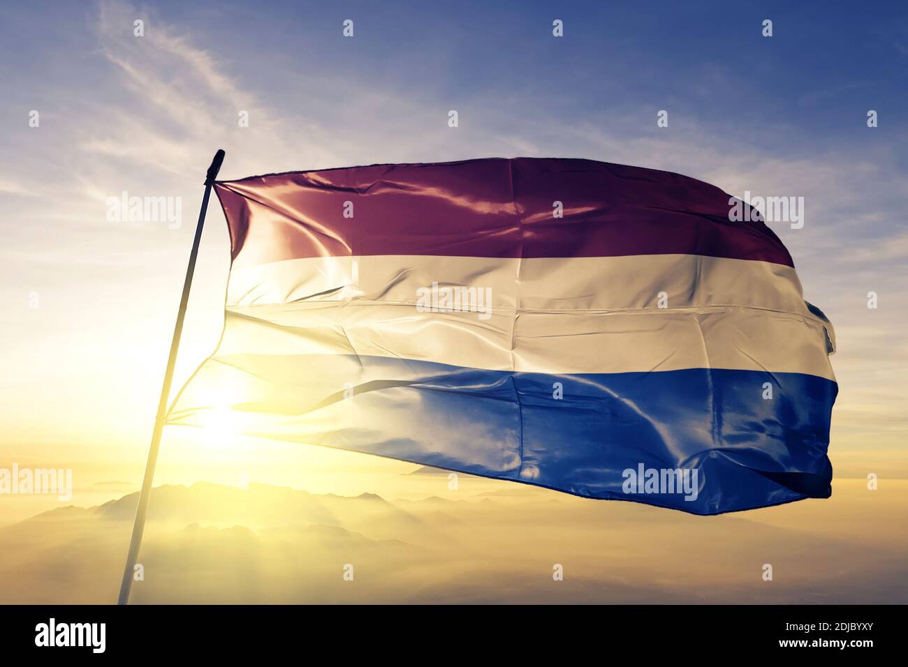 Netherlands flag waving on the top sunrise mist fog Stock Photo - Alamy