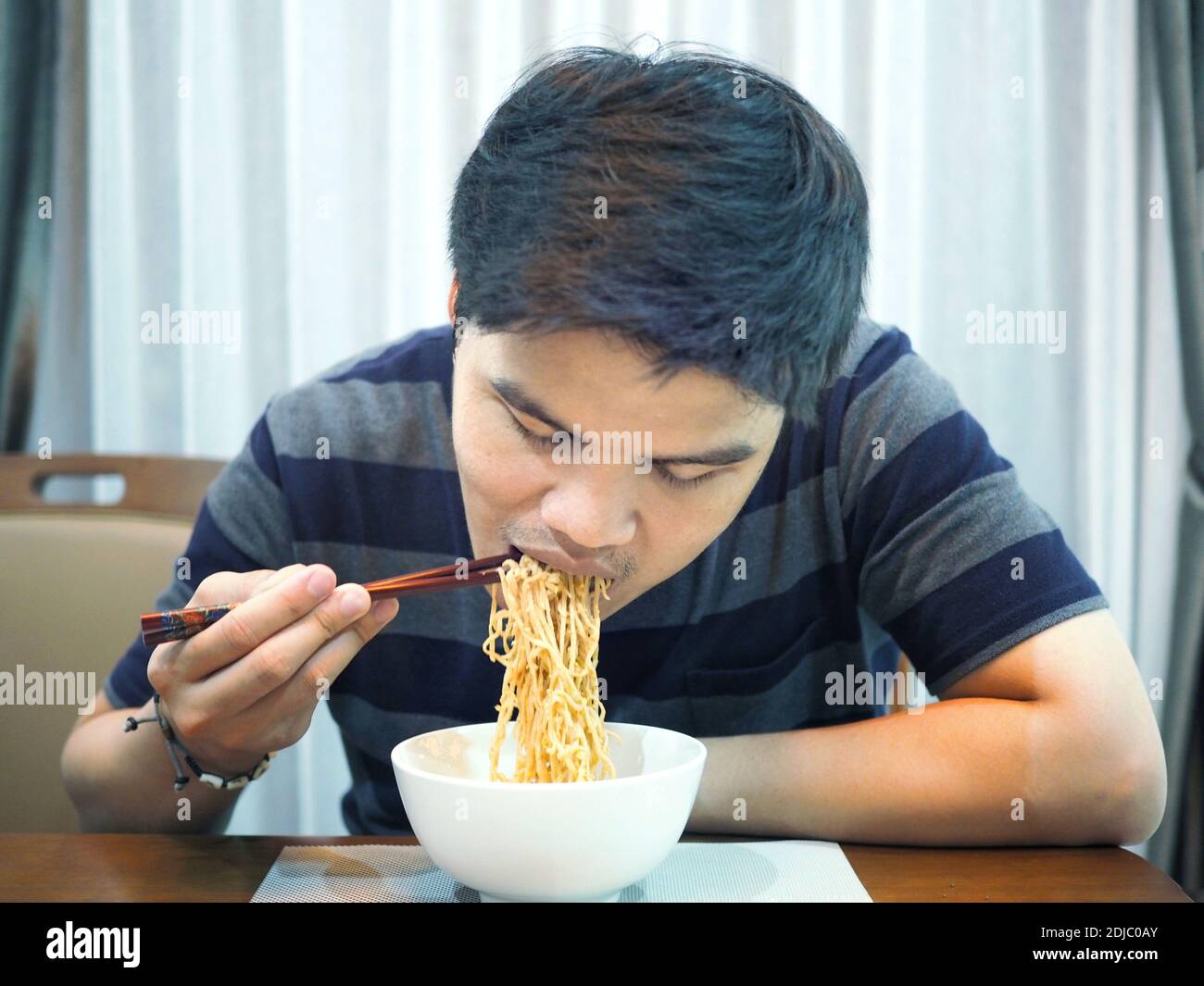 Indian man eating noodles hi-res stock photography and images - Alamy