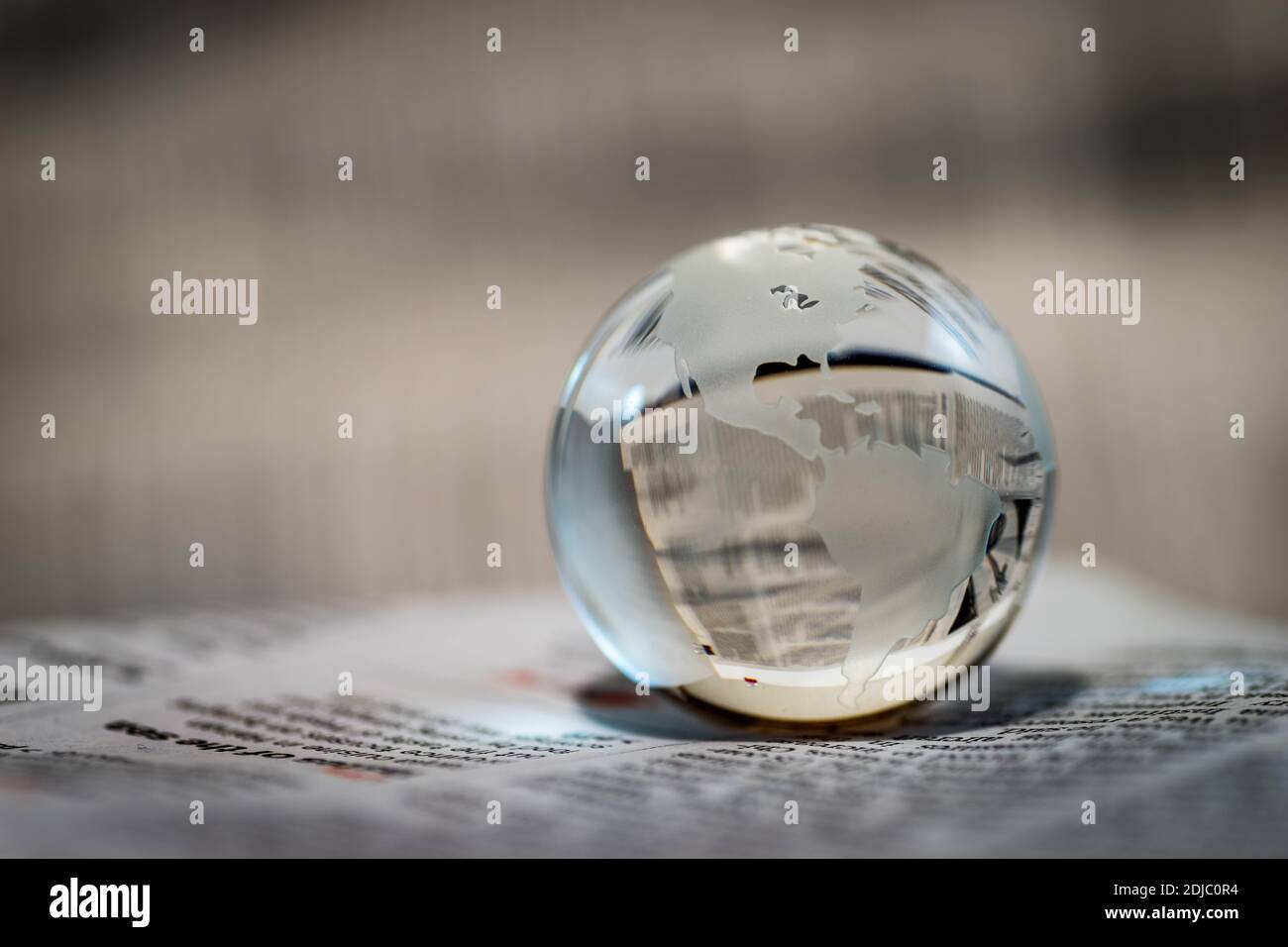 Glass globe on newspaper hi-res stock photography and images - Alamy