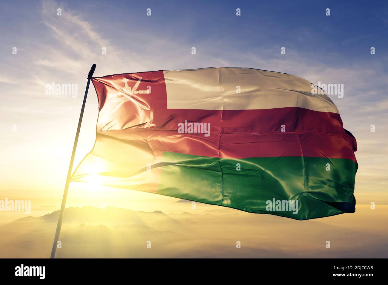 Oman flag waving on the top sunrise mist fog Stock Photo - Alamy