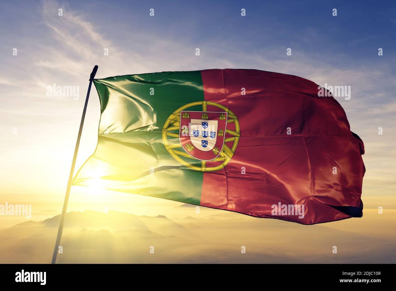 Portugal flag waving on the top sunrise mist fog Stock Photo - Alamy